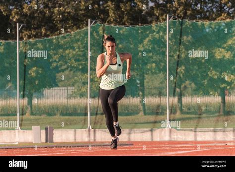 Athlete Woman Starting To Run On The Athletic Track From The Three