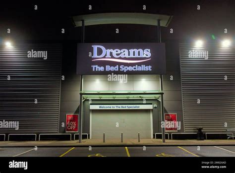 Dreams The Bed Specialist Shop Sign Above Front Entrance At Night With
