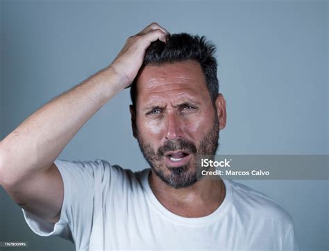 극적인 얼굴 표정과 제스처 스튜디오 배경에 고립에 압도 하 고 좌절 그의 머리에 손을 가진 젊은 매력적인 걱정 하 고 스트레스