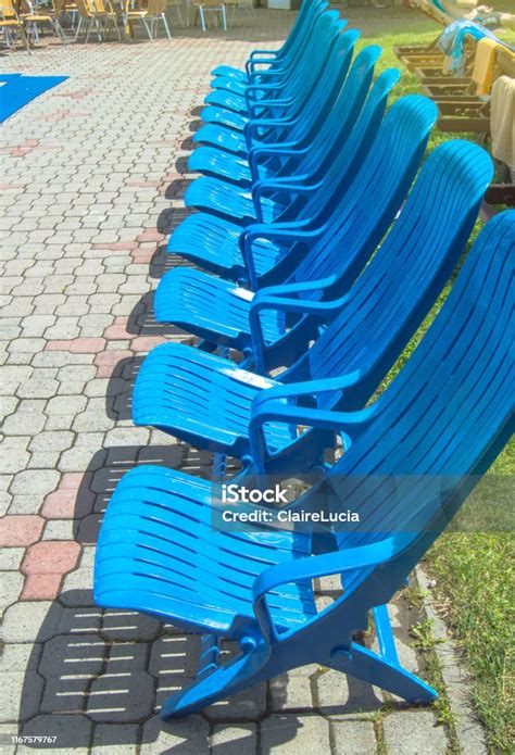 야외 수영장 옆에 있는 여름 레크리에이션 공간 더운 여름 의날 수직 프레임에 포장 슬래브에 줄지어 서있는 현대적인 빈 플라스틱 블루 일광욕 용 라운저 0명에 대한 스톡 사진