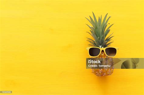 나무 노란색 배경 위에 세련 된 선글라스에 잘 익은 파인애플 열 대 여름 휴가 개념입니다 탑 Vew 개념에 대한 스톡 사진 및