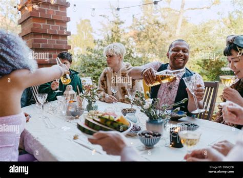 Happy Friends Of Lgbtq Community Drinking Wine While Sitting At Table
