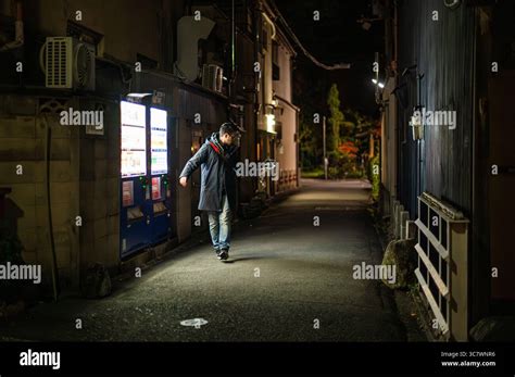 Man Filming At Night In Japanese Alley With Vending Machines Stock