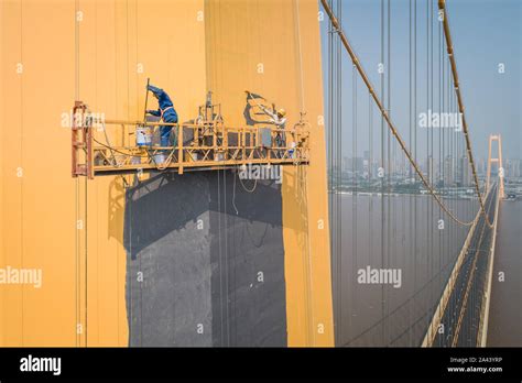 Chinese Workers Labor At The Construction Site Coating The Pillars Of