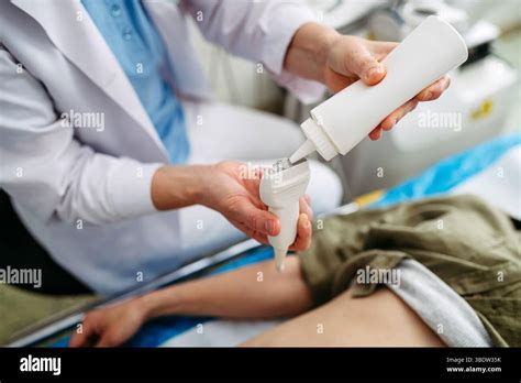 radiologist applying gel to ultrasound probe before abdominal scan