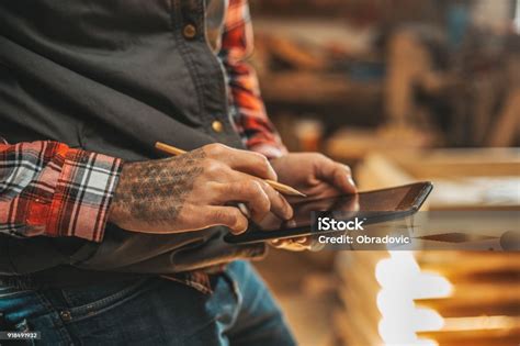태블릿을 사용 하 여 그의 워크샵 Pn 가구 프로젝트에서 작업 하는 목수 수리공에 대한 스톡 사진 및 기타 이미지 수리공 문신 작업대 작업 장비 Istock