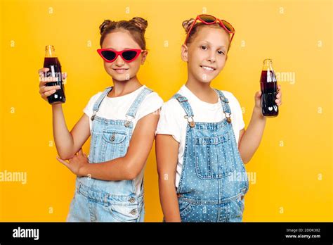 Two Teenage Girls Stylish Girlfriends In Sunglasses With Soft Drinks