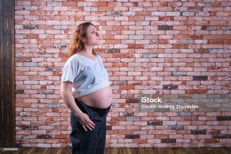 빨간 벽돌 벽의 배경에 임신 한 배를 가진 성인 여성 텍스트 에 대한 공간을 복사 30 34세에 대한 스톡 사진 및 기타 이미지