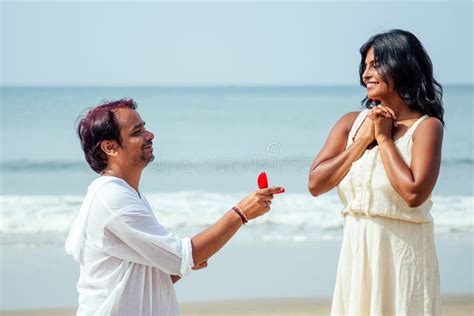 Indian Male Making Proposal With Engagement Ring And Roses To His Girlfriend At Sea Beach