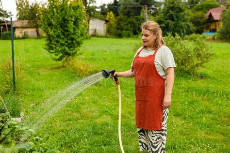 Mujer Feliz Con Delantal Trabajando Al Aire Libre En Plantas De Rociado