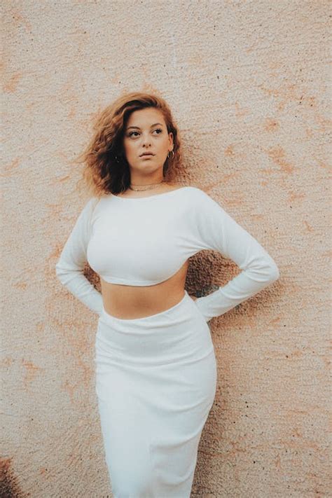 Model In A White Crop Top With Long Sleeves And A Maxi Skirt Standing