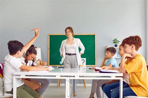 Beautiful Young Smiling Teacher Asks Questions To Her Students At