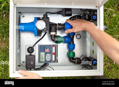 Installation Of A Drip Irrigation System A Man Assembles A System For Automatic Regulation Of