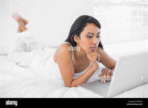 Peaceful Woman Lying On Her Bed Using Her Notebook Stock Photo Alamy