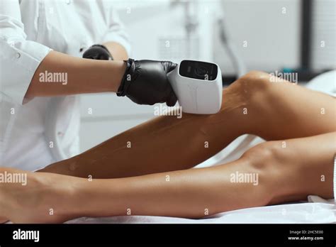 Young African Woman Getting Laser Hair Removal On Her Thighs Stock