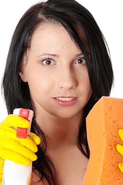 Premium Photo Beautiful Woman Holding Sponge And Spray Bottle While Standing Against White