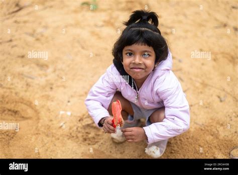 A Small Girl Is Having A Blast Playing In The Mud She Is Laughing And