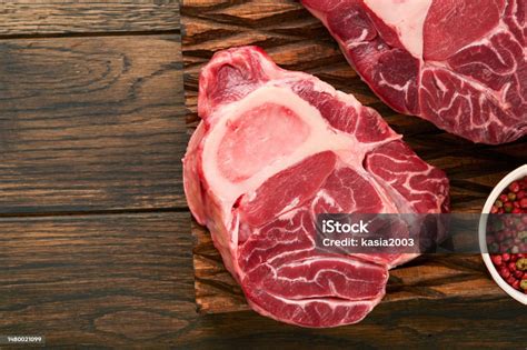 오소 부코 생 스테이크 고기 바베큐 고기 원시 신선한 크로스 컷 송아지 정강이와 조미료 후추 로즈마리 백리향 및 오래된 나무