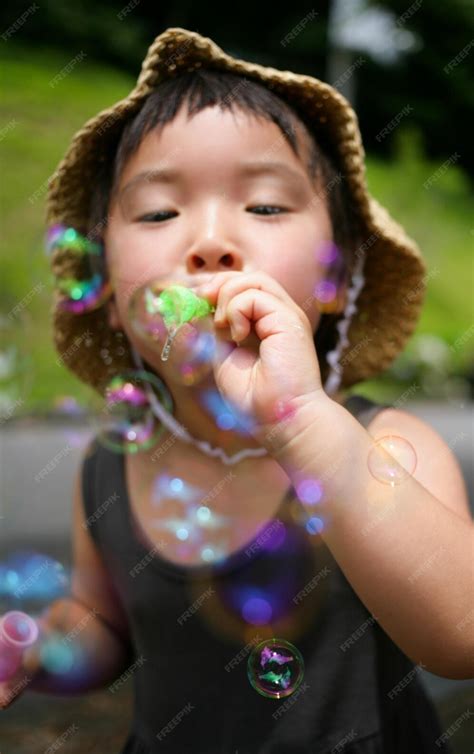 Premium Photo Close Up Of Cute Girl Blowing Bubbles