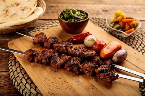 Shish Kebab 또는 쇠고기 Seekh Boti는 나무 배경 측면보기에 격리 된 나무 커팅 보드에서 제공됩니다 시시 케밥에