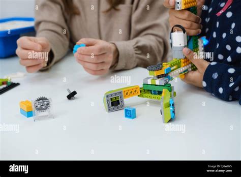Ragazzi Multietnici A LEZIONE STEM Costruire Robot In Classe Con Insegnante Di Donna Bambini
