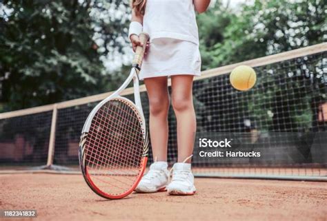 테니스 클럽에서 어린이를 위한 여름 활동 테니스 코트에 스포츠 어린 소녀의 자른 이미지입니다 육상 아이 소녀는 라켓으로 테니스 공을 친다 건강한 생활방식에 대한 스톡 사진