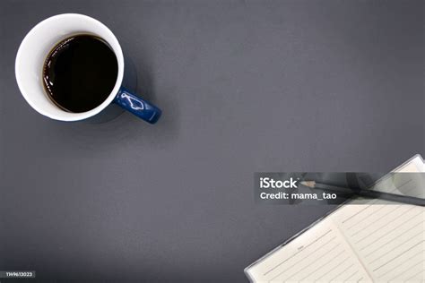 오래 된 까만 비닐 사무실 책상 짜임새에 있는 까만 커피의 노트북과 파란 컵을 가진 연필 복사 공간 작업 공간 배경으로 평면도