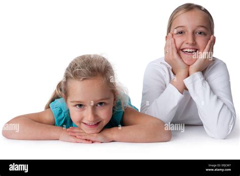 Portrait Of Two Blond Sisters Lying On The Floor On White Background
