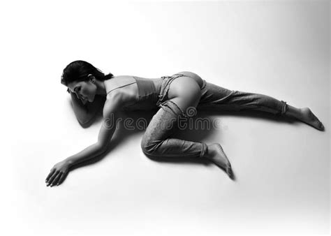 Black And White Top View Of Young Pretty Woman In Torn Jeans With Naked Booty And Top Lying On