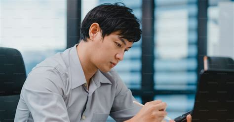 성공적인 임원 아시아 젊은 사업가 스마트 캐주얼웨어 드로잉 쓰기 및 디지털 태블릿 컴퓨터로 펜을 사용하여 현대 사무실에서 영감 검색 아이디어 작업 프로세스를 생각합니다