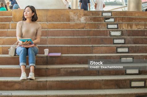 아름 다운 아시아 여성 대학생 그녀의 책과 야외 서 커피 한 잔 들고 사람 고등학교 프로그램 스마트 십 대 개념을 학습 하는