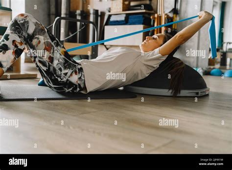 White Woman Working Out With Expander Tape During Pilates Practice In