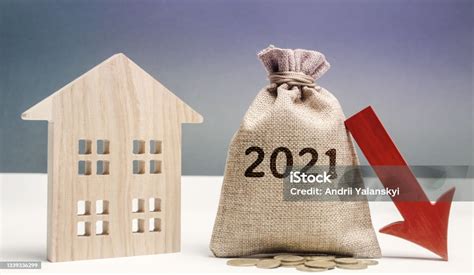 목조 주택과 아래로 화살표와 2021 돈 가방 부동산 시장 개념을 예측 금리가 하락하고 있습니다 투자 이익 및 소득 주택 가격의 하락 모기지 대출 부동산에 대한 스톡 사진