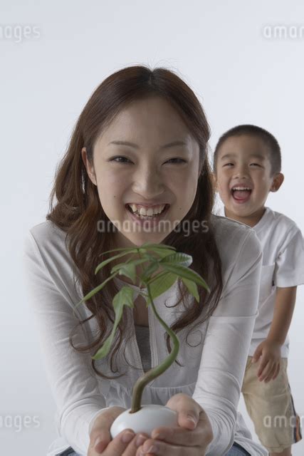 植物を持っている女性と笑っている男の子の写真素材 Fyi04067671 ストックフォトの Qlean Market