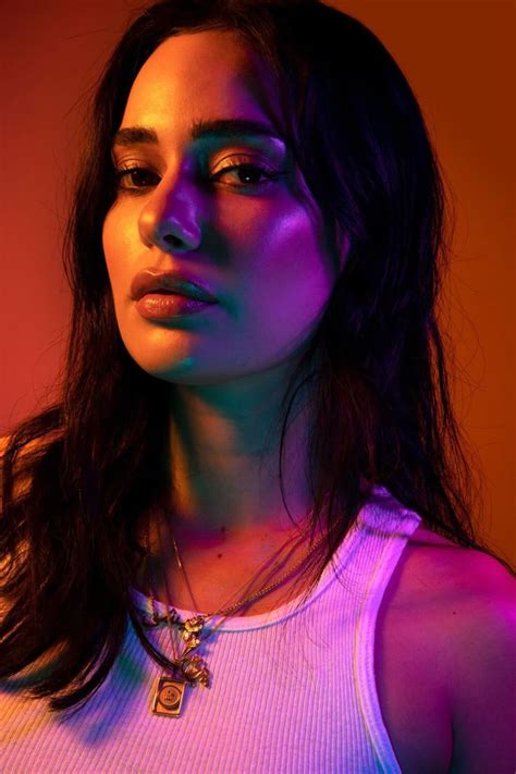 A Woman With Long Hair Wearing A White Tank Top And Colorful Lights On