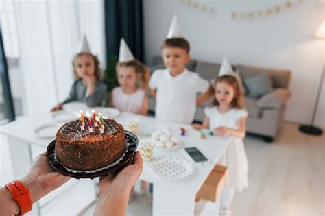 촛불로 케이크를 들고 있는 여자 생일 축하합니다 어린이 그룹이 낮에 집에서 함께 있습니다 4 5세에 대한 스톡 사진 및 기타