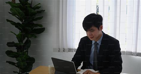 컴퓨터 태블릿에서 일하고 현대 사무실에서 새로운 프로젝트와 관련된 그의 계획에 대해 생각하는 매력적인 사업가 사진