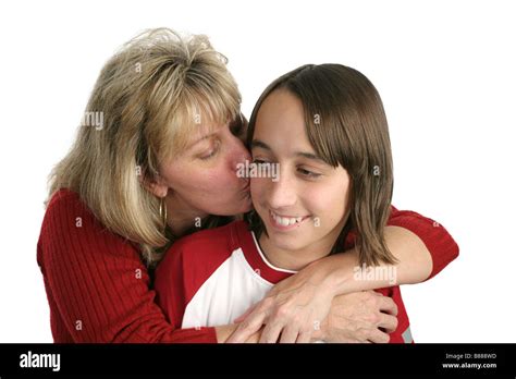 Une mère donnant un baiser sur la joue de son fils adolescent isolé Photo Stock Alamy