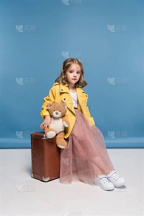 带着泰迪熊的漂亮女孩坐在行李箱上看着相机素材 花瓣网