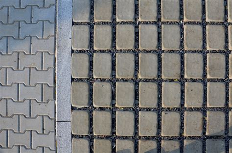 도시에 새로운 설립 된 거리 세로 주차장은 자갈로 가득 틈새 타일에 침투 회색 콘크리트로 만들어집니다 도로 충돌에서 물의 유출을 제한하는 조치 거리에 대한 스톡 사진 및