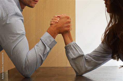 Homme et femme d affaire faisant un bras de fer sur un bureau au travail Symbolisant l égalité