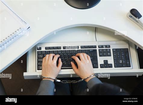 Young Businesswoman Handcuffed To Her Office Chair Directly Above