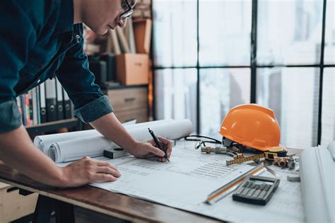 사무실 책상과 계산기 삼각형 눈금자 안전 안경 나침반 블루프린트의 버니어 캘리퍼에서 도면 검사 및 쓰기로 작업하는 엔지니어링 엔지니어 건축가 산업 및 공장 개념 35 39