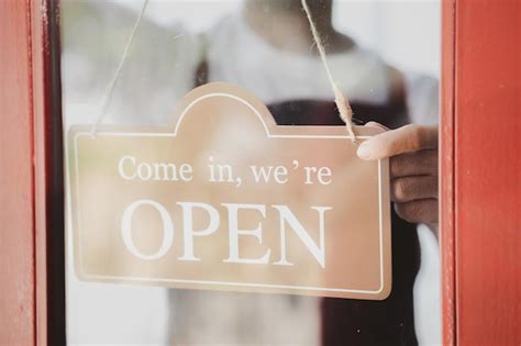 Premium Photo Man Holding Openclose Sign In Front Of Entrance Goods