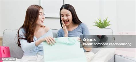 행복한 미소 얼굴로 종이 봉투를 여는 아시아의 아름다움 두 명 집에서 쇼핑 경험으로 새로운 정상적인 온라인 비즈니스 성소수자에