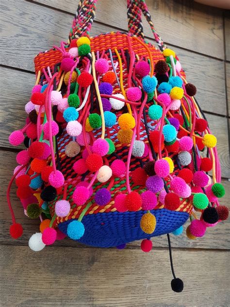 กระเป๋าสานจากสายลีซอ ชนเผ่าลีซอ สีสันสดใส แต่งปอมๆ ฟรุ้งฟริ้ง น่ารักค่ะ ขนาด กว้าง 13 สูง 11