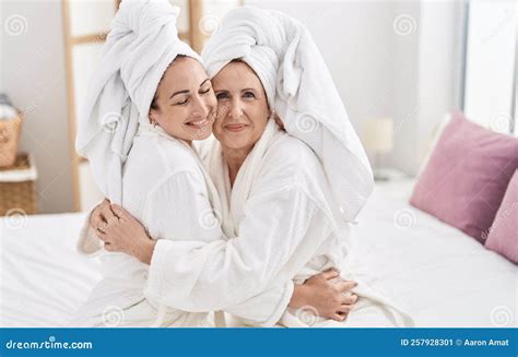 Mother And Daughter Wearing Bathrobe Hugging Each Other At Bedroom