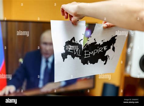 Hands Tearing Apart Paper With Black Contours Of Russia With A Phrase