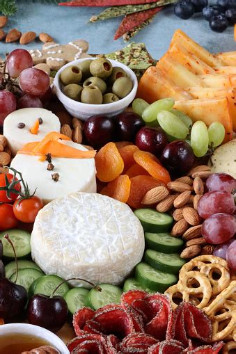 크리스마스 Charcuterie 보드 재료 브리 눈사람 진저 브레드 맨 살라미 로즈 포도 나무 토마토 빨간색과 흰색 포도 프레첼