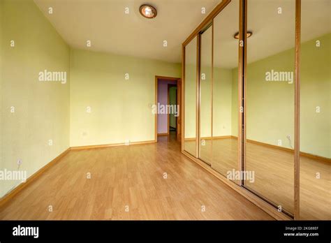 Empty Room With Laminated Flooring And A Wall Covered With A Built In